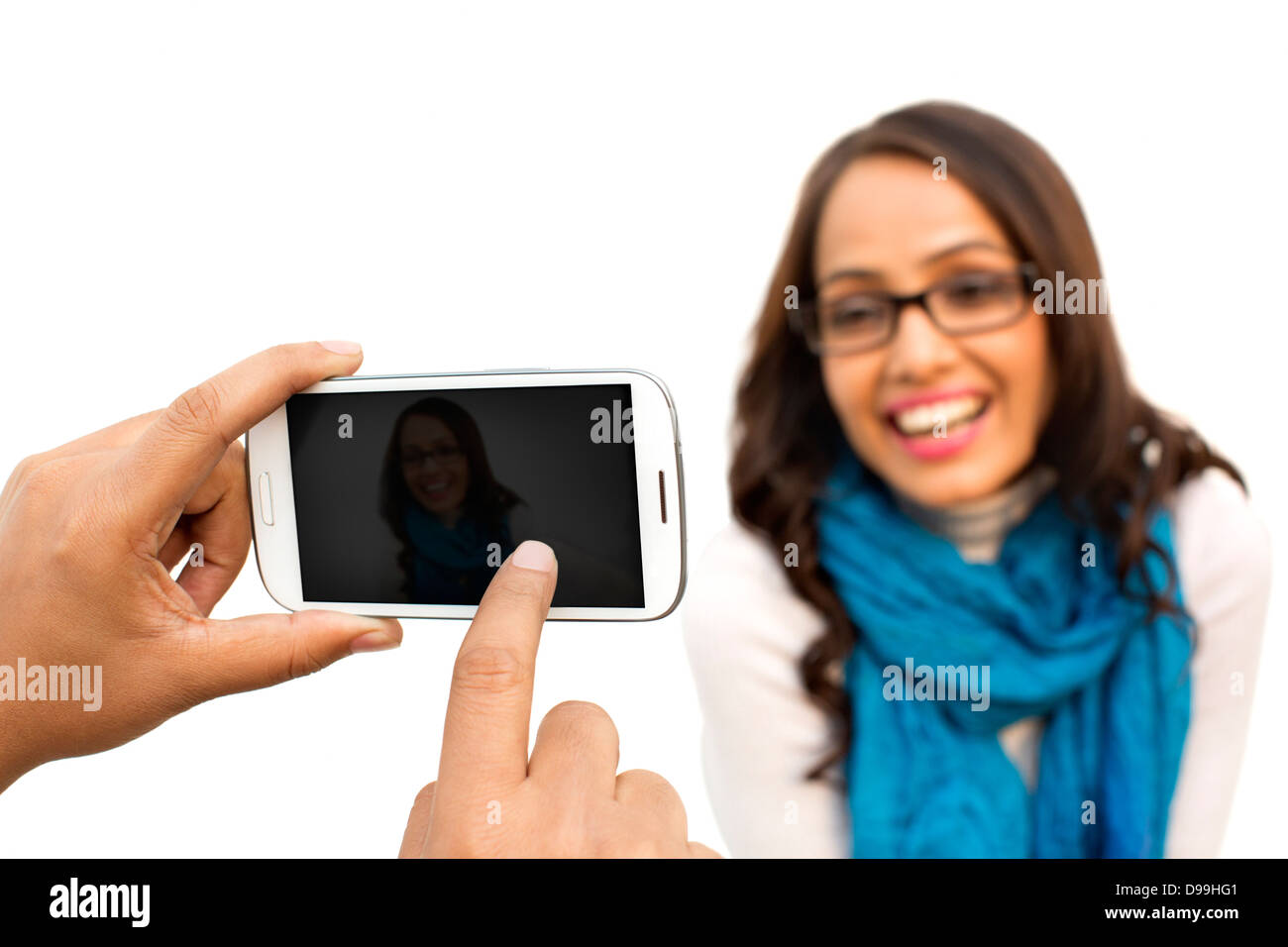 Close-up of a person's hand taking picture of a woman with a mobile ...
