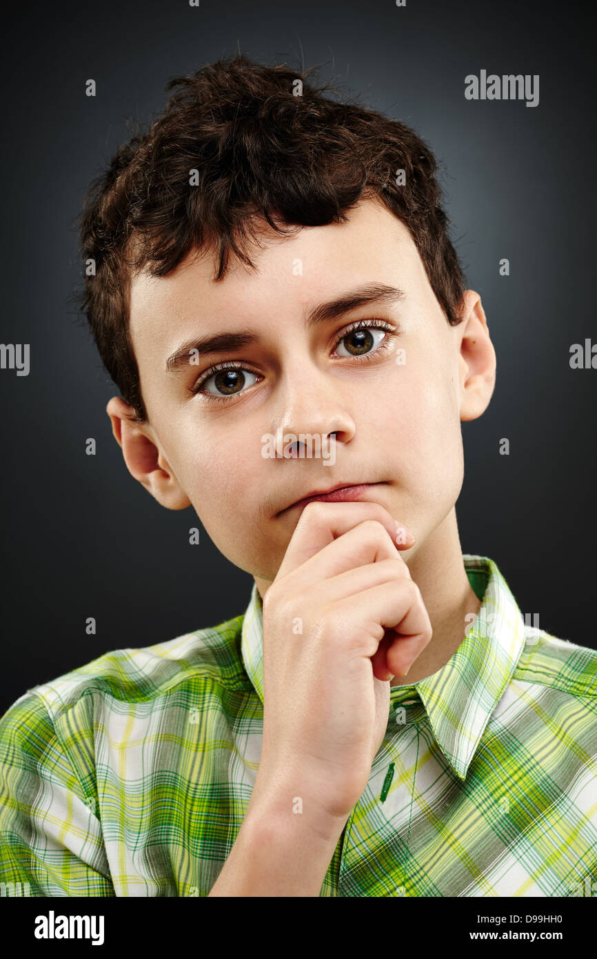 Closeup portrait of a pensive boy over gray background, studio shot ...