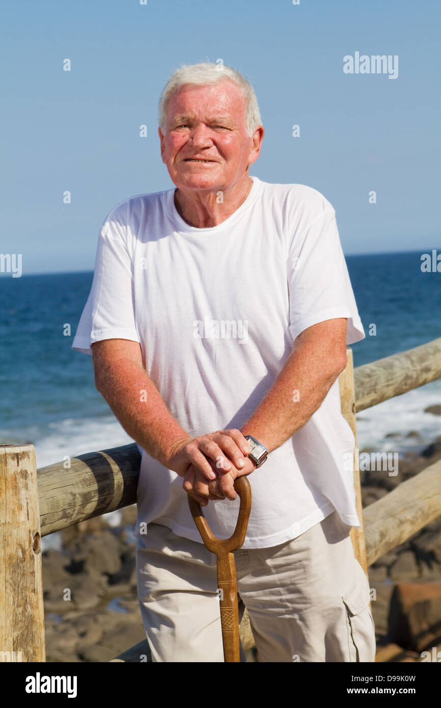 portrait of a senior man holding cane on beach Stock Photo - Alamy