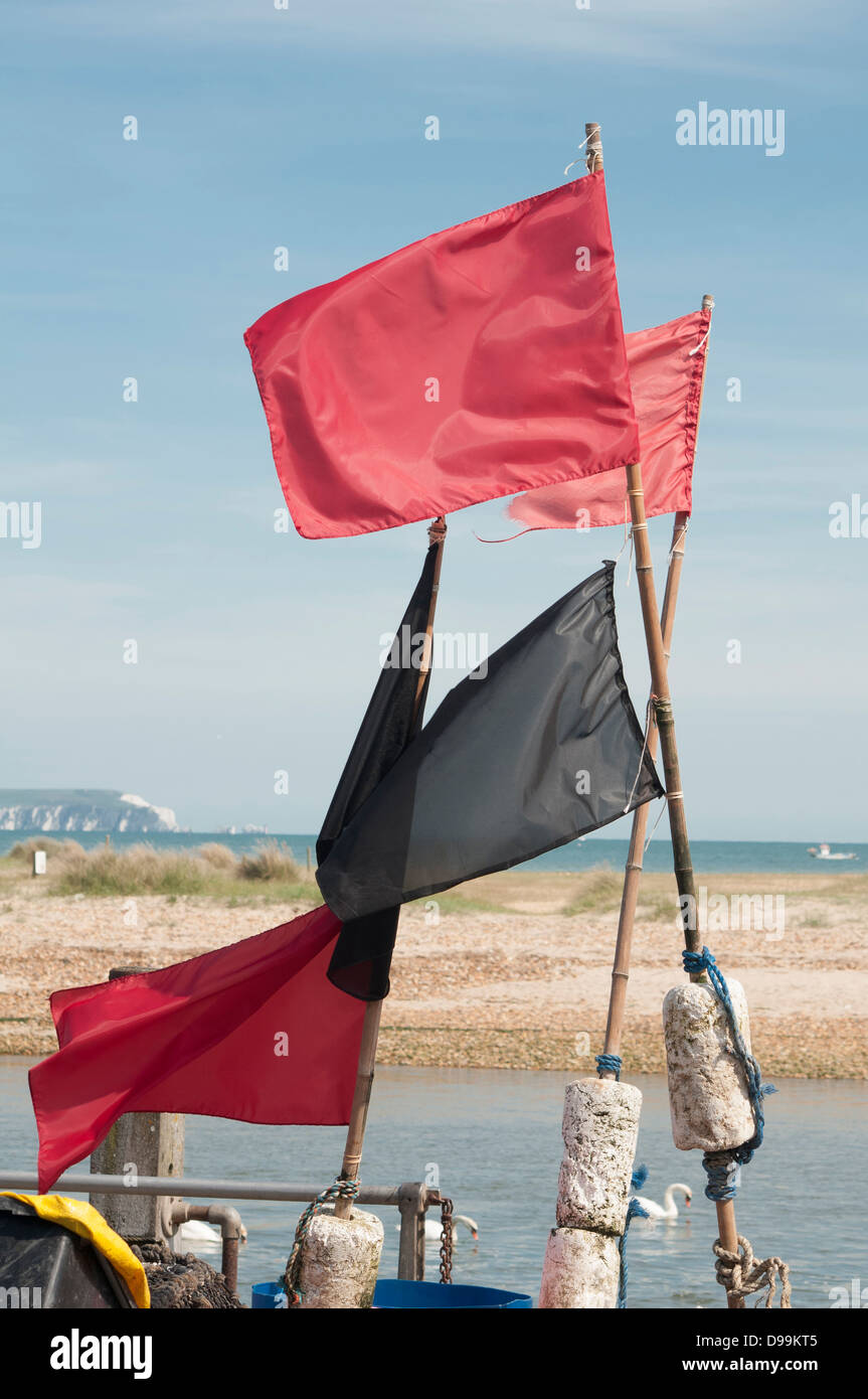 red & black flags on lobster pots on the quayside Stock Photo - Alamy