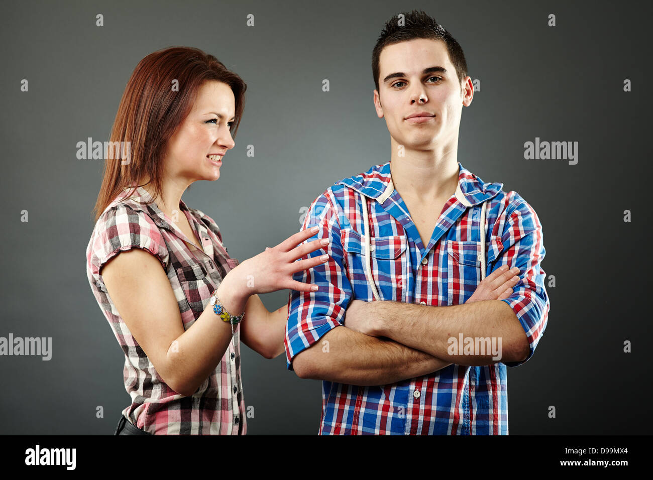 Young woman angry with her indifferent husband. Gray background Stock ...