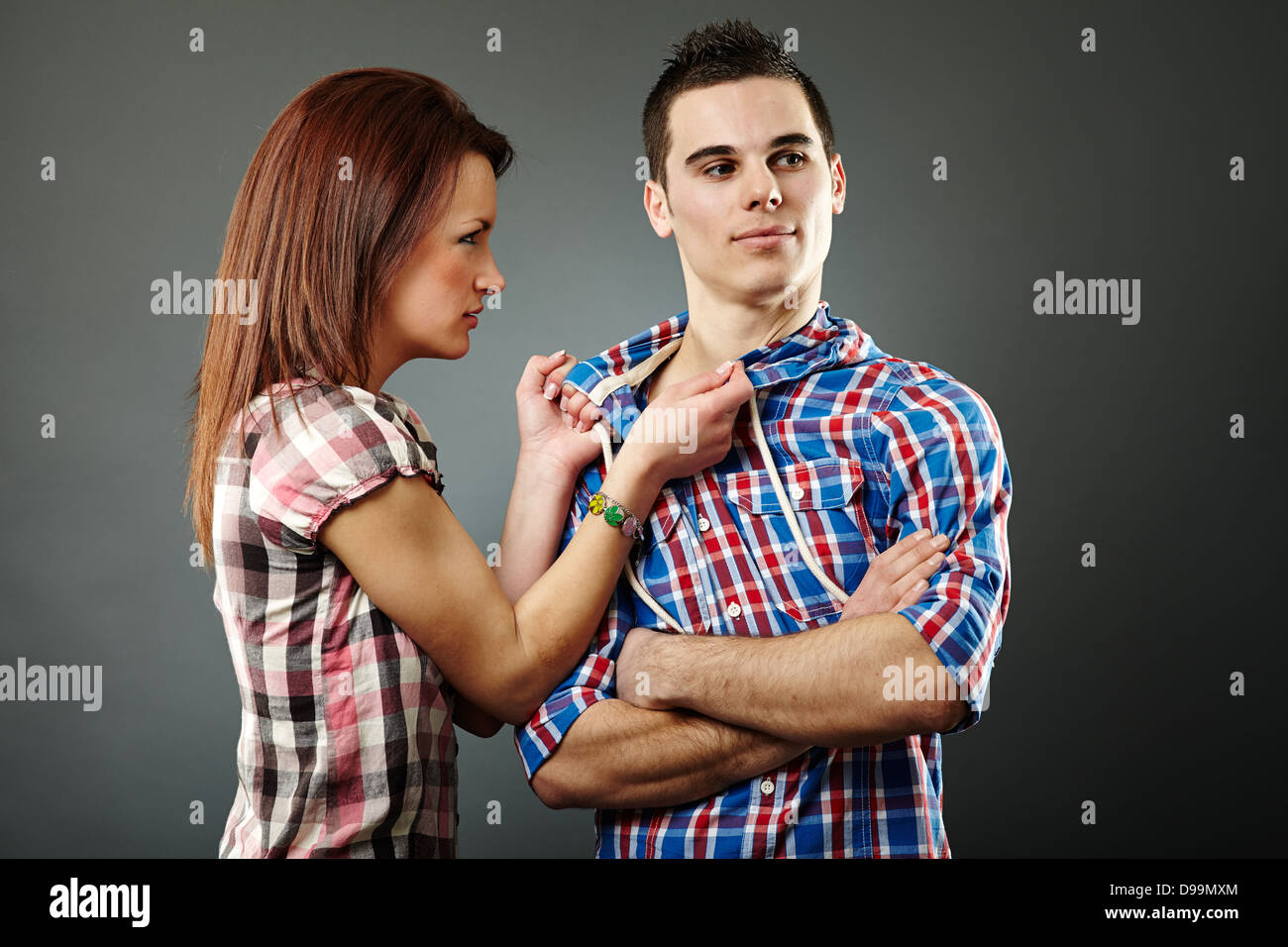 Young woman angry with her indifferent husband. Gray background Stock ...
