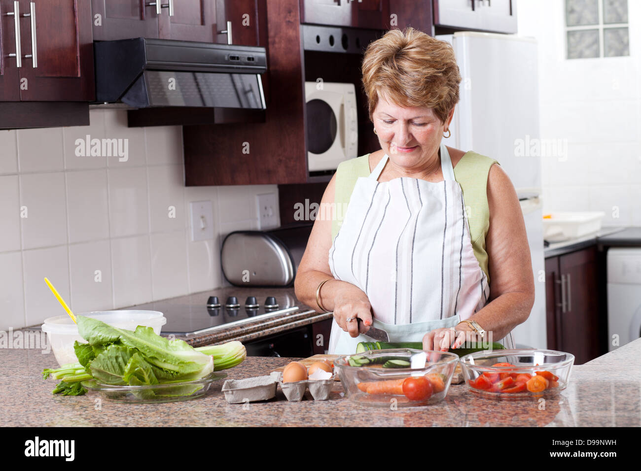 elderly woman cooking food in home kitchen Stock Photo - Alamy