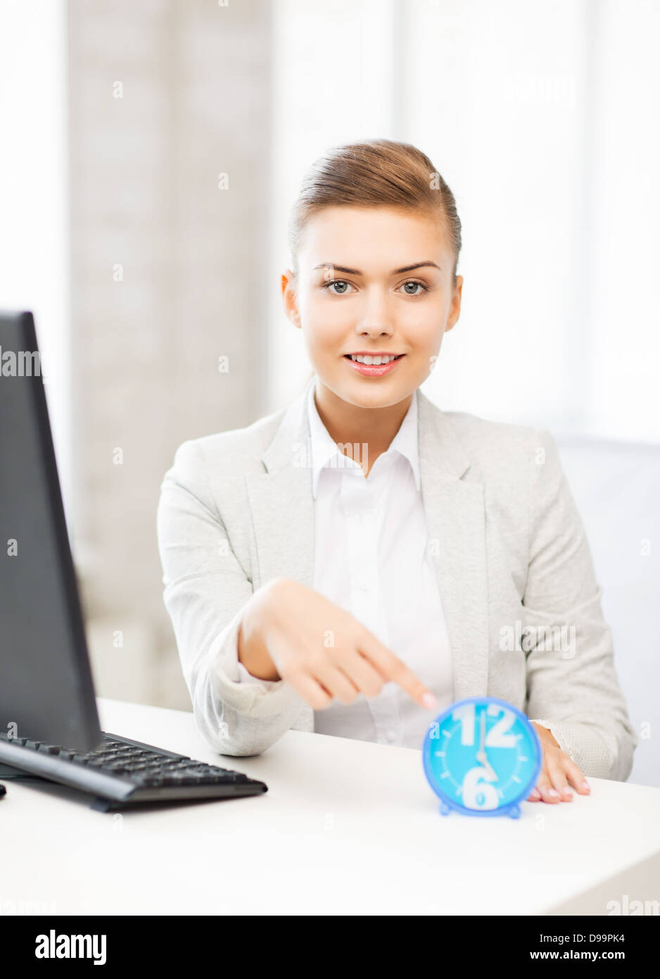attractive businesswoman pointing at clock Stock Photo - Alamy
