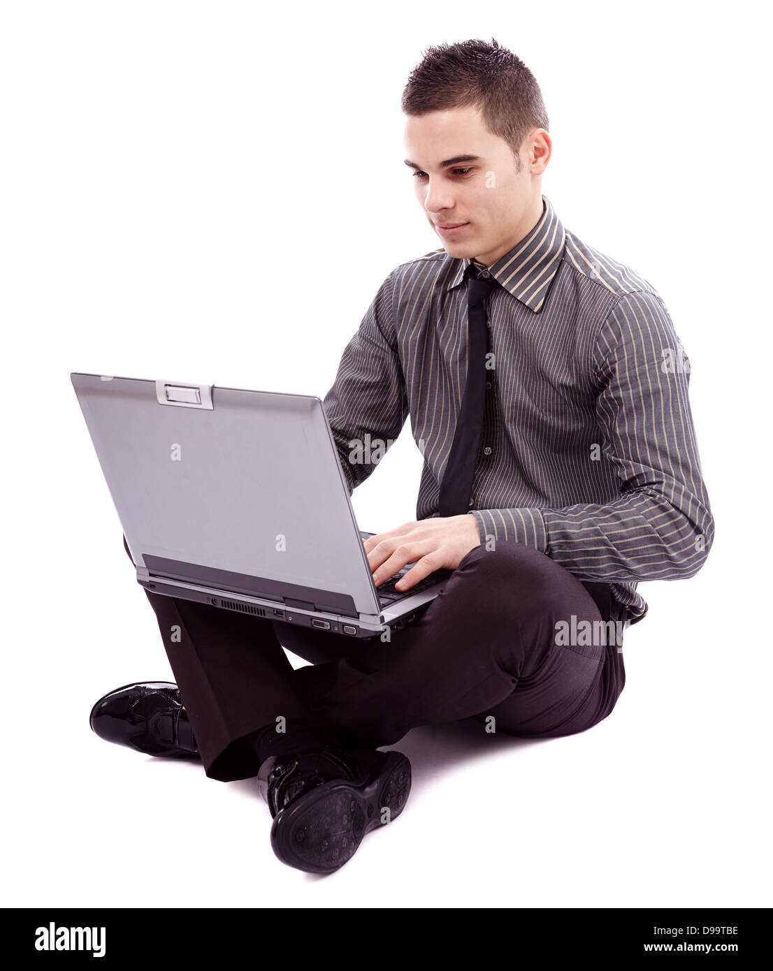 Full length pose of young businessman sitting on the floor and writing ...