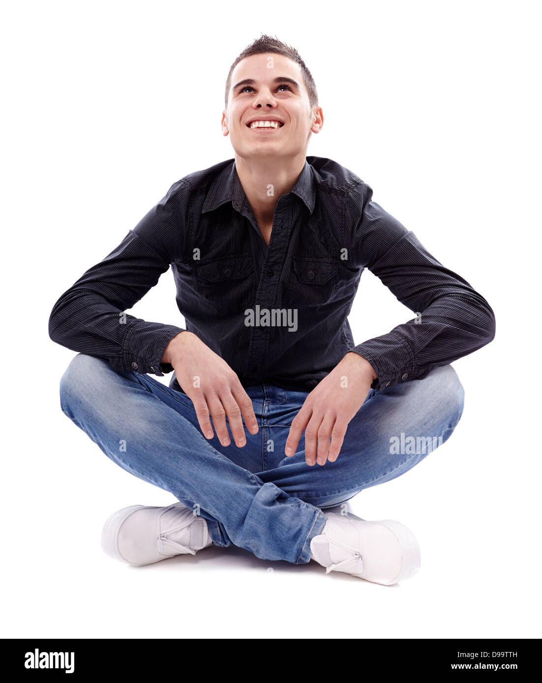 Full length pose of young man sitting on the floor cross legged ...