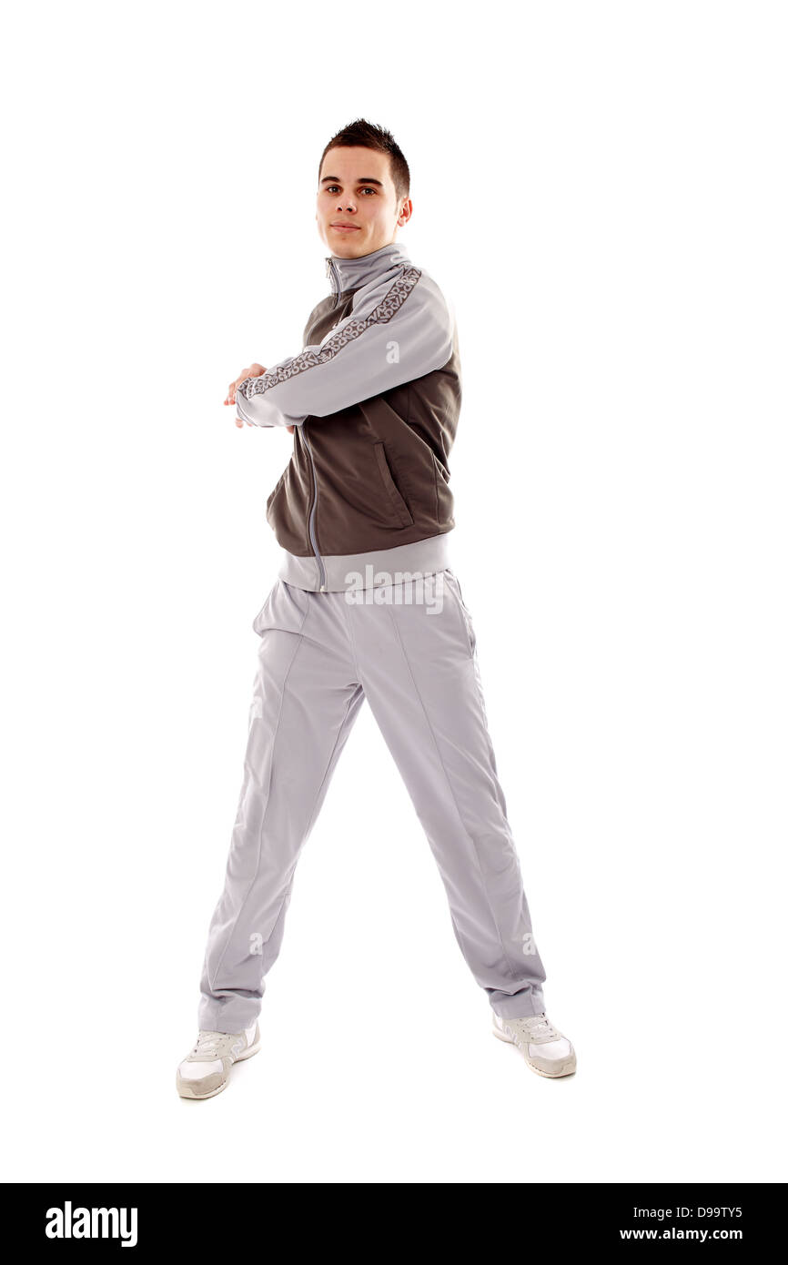 Full length pose of a young man doing spins, wearing a track-suit and ...