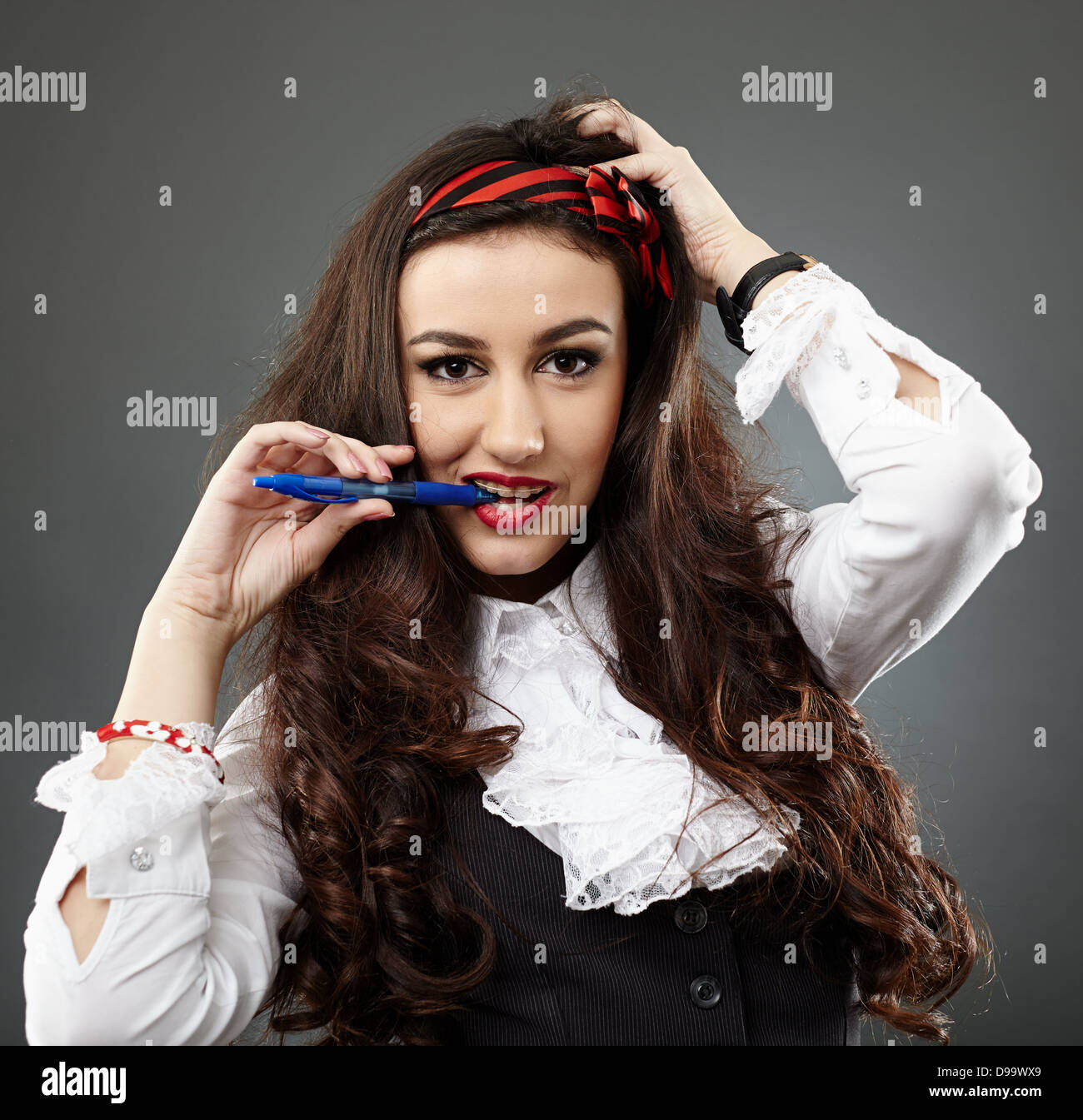 Closeup of sensual young schoolgirl, holding a pen between her teeth ...