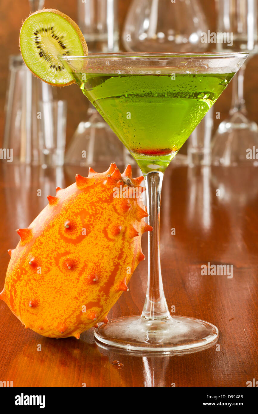 bright green cocktail served on a busy out of focus bar with horned ...