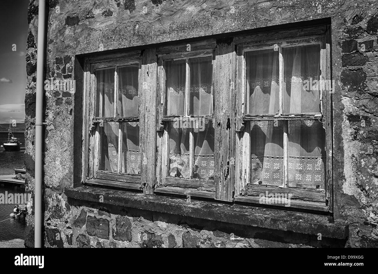 Faded and worn out wooden framed window in derelict property Stock ...