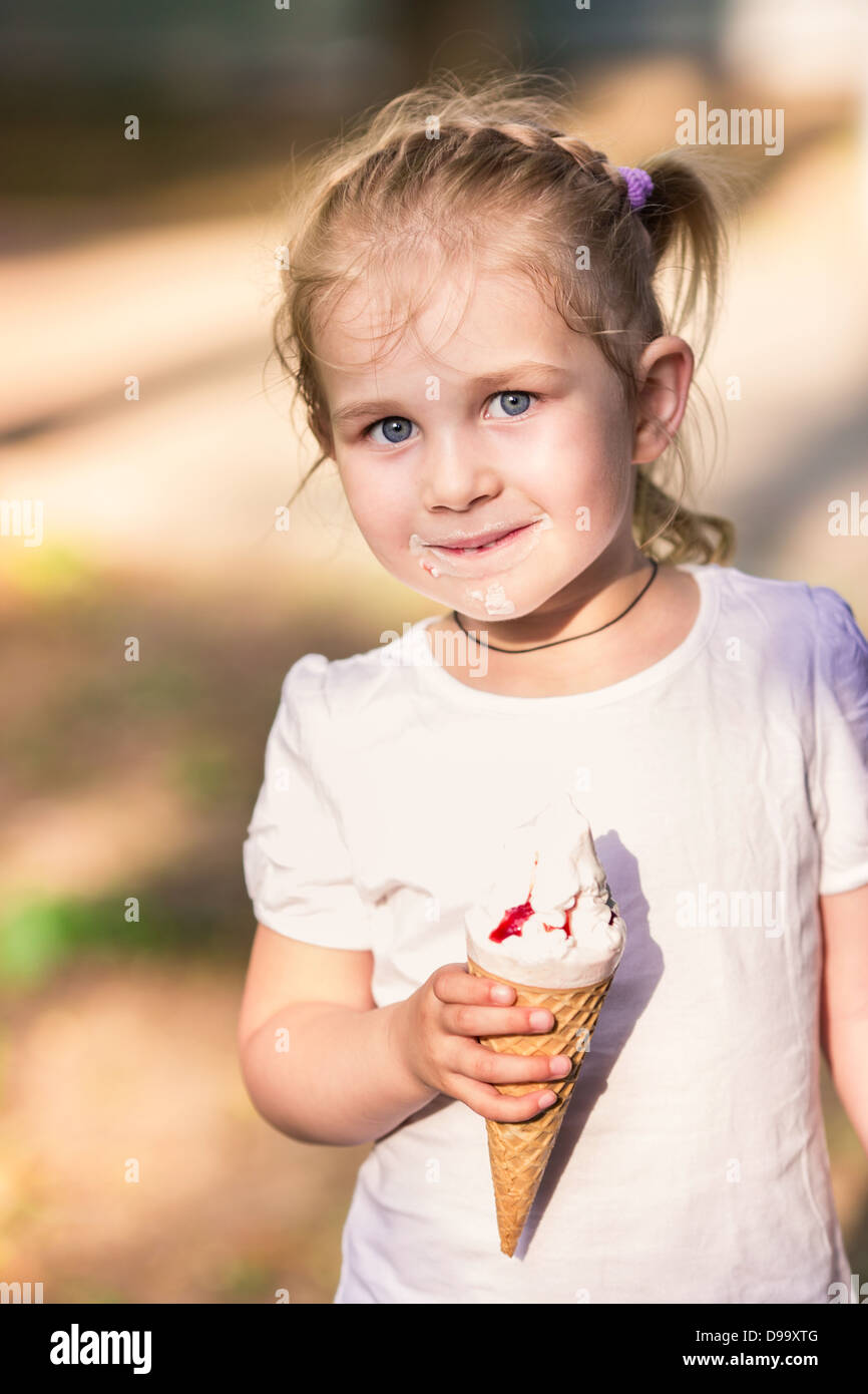 Happy cute child eating ice cream outdoor Stock Photo - Alamy