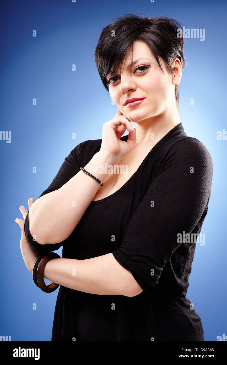 Closeup portrait of a woman thinking with hand on chin on blue ...