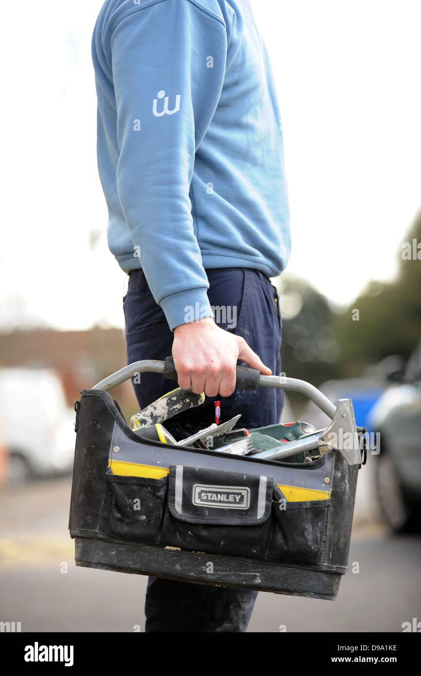A builder holding a tool box at waist level Stock Photo - Alamy