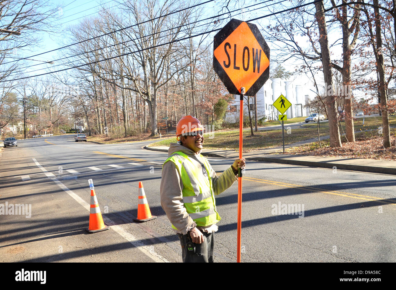 Worker holding up a slow sign Stock Photo - Alamy
