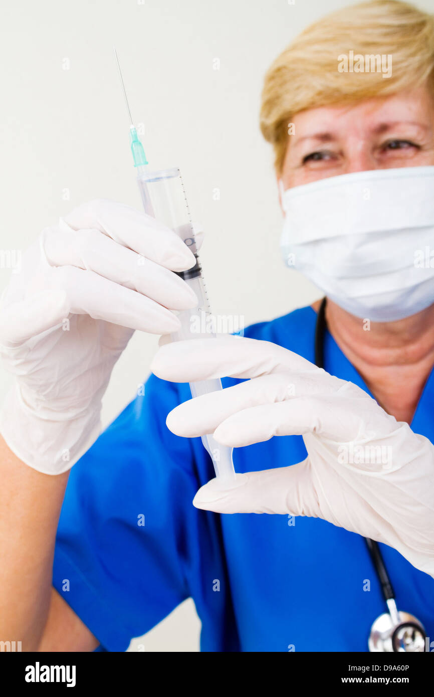 female senior nurse holding syringe Stock Photo - Alamy