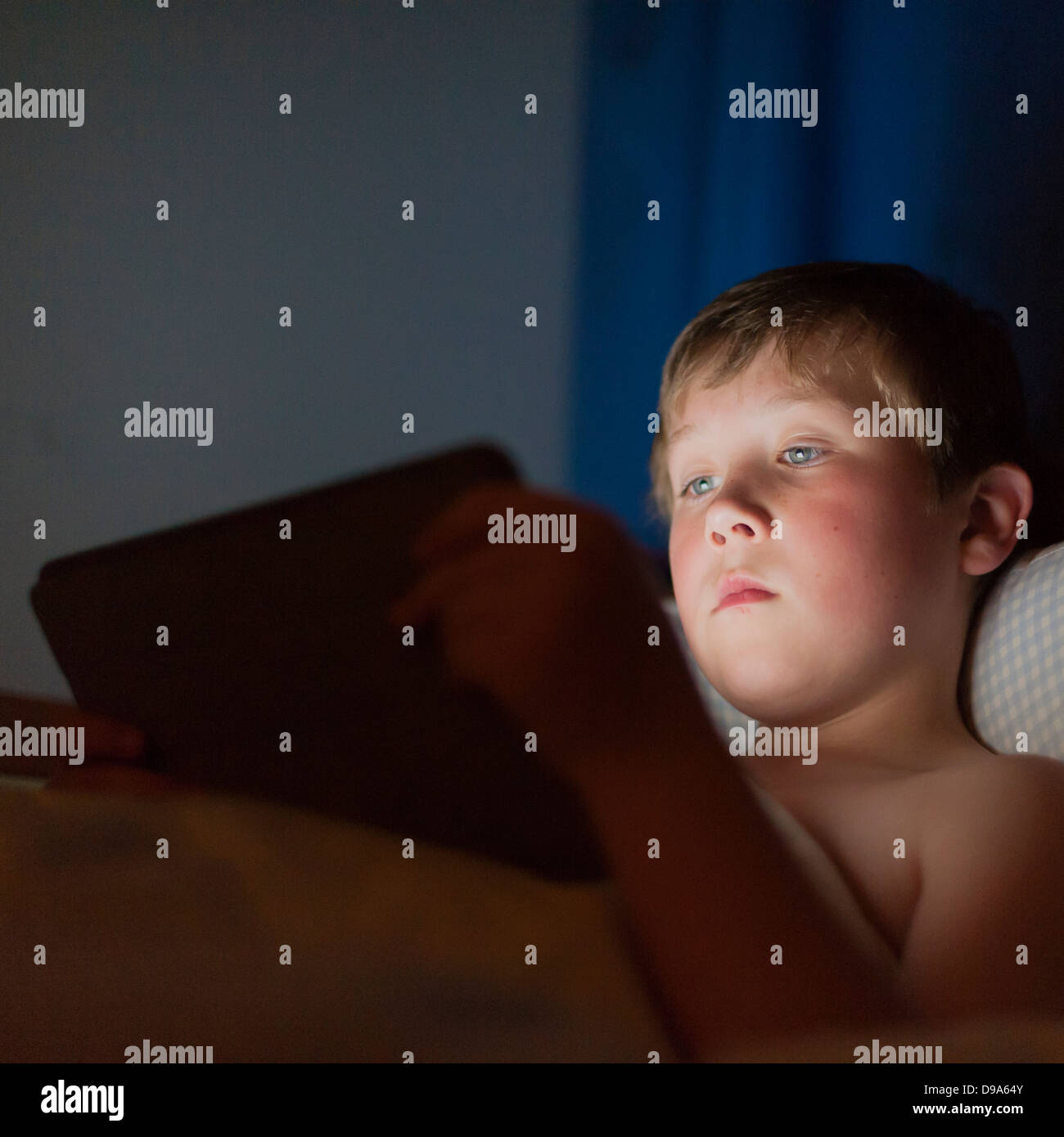 A 9 year old boy using a tablet on the internet in bed Stock Photo - Alamy