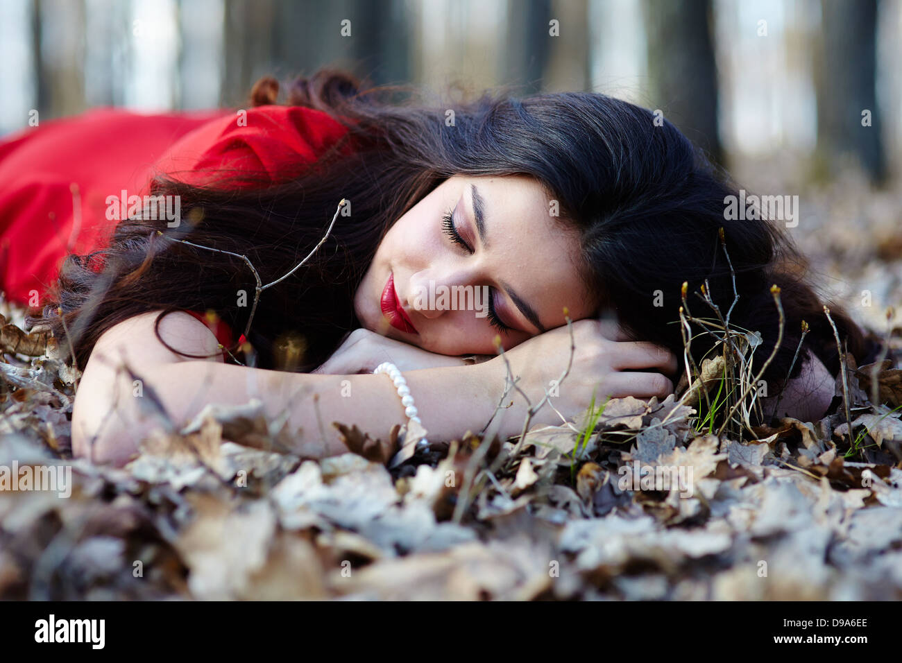 Portrait of a beautiful woman sleeping on the ground in the woods Stock ...