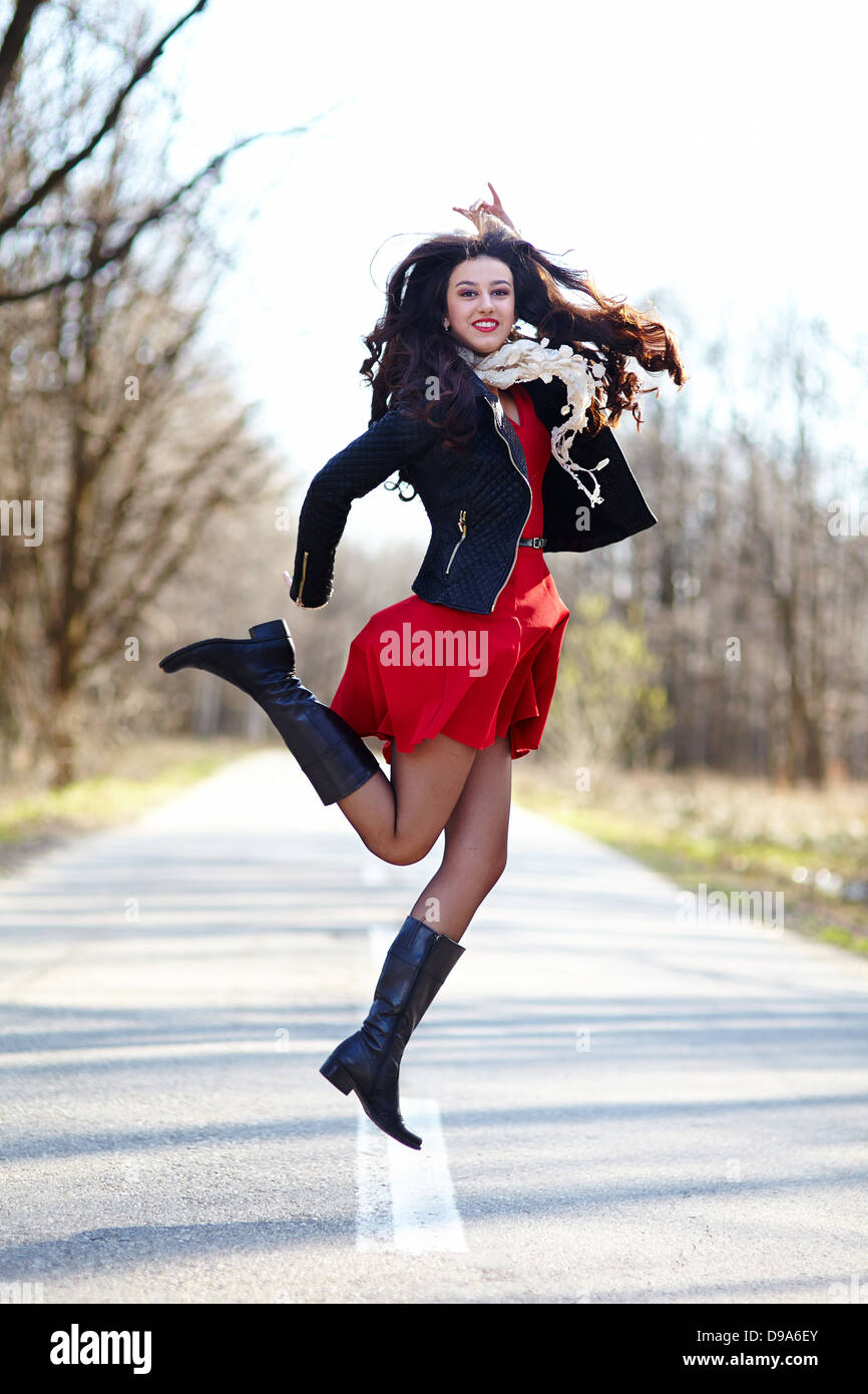 Full length portrait of a beautiful woman jumping on the road Stock ...
