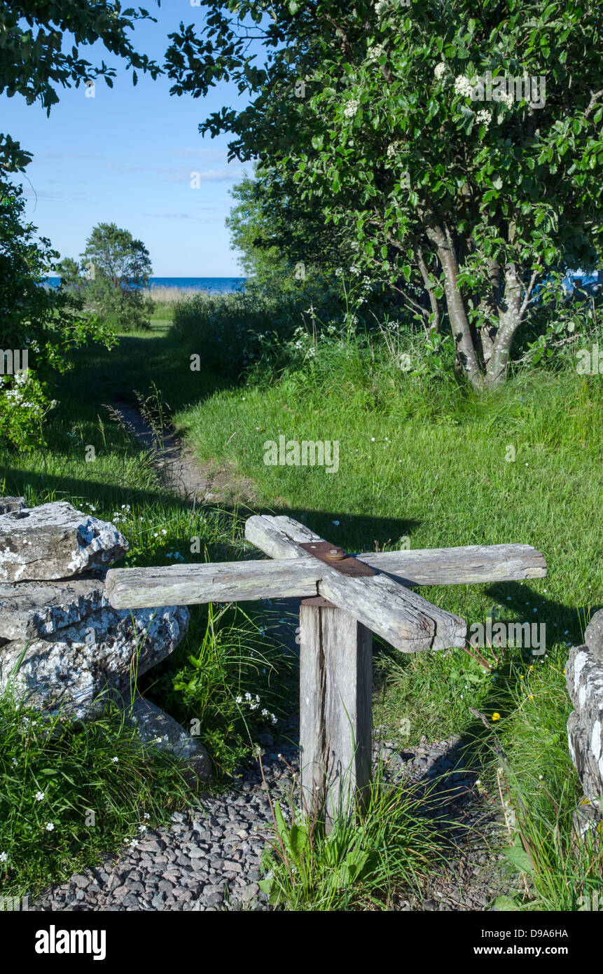 Old wooden turnstile at a pathway to the coast of Baltic sea. From the ...