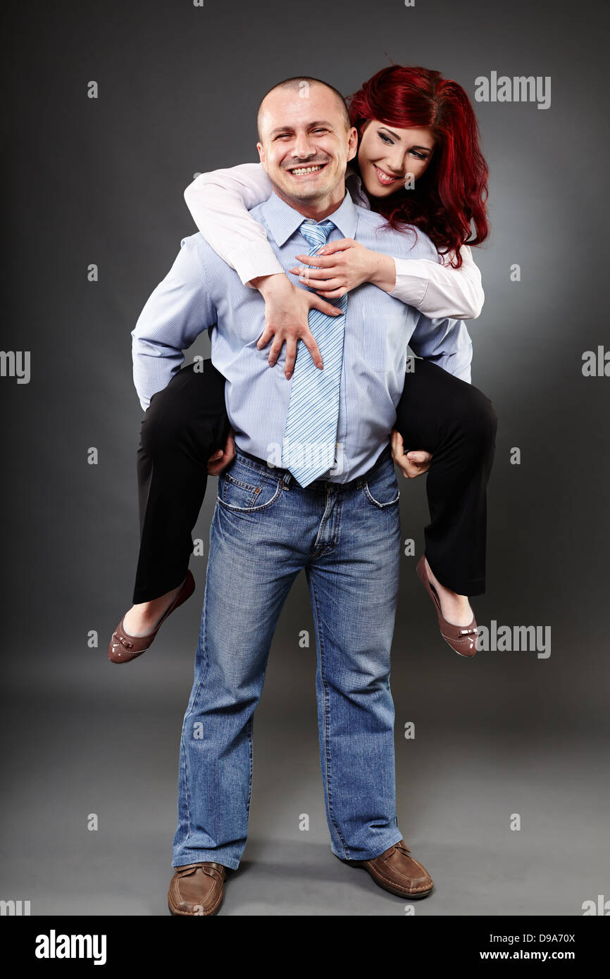 Full length portrait of a businessman carrying his partner in the back ...