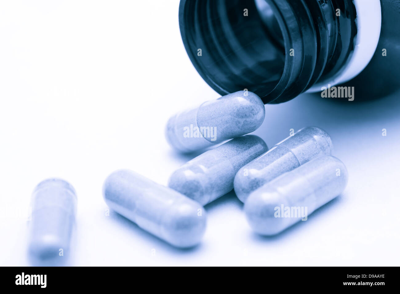 Prescription capsules spilling from an open bottle Stock Photo - Alamy