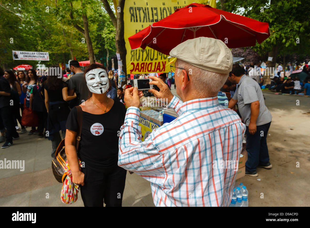 Senior man taking a picture of his wife wearing an anonymous mask ...