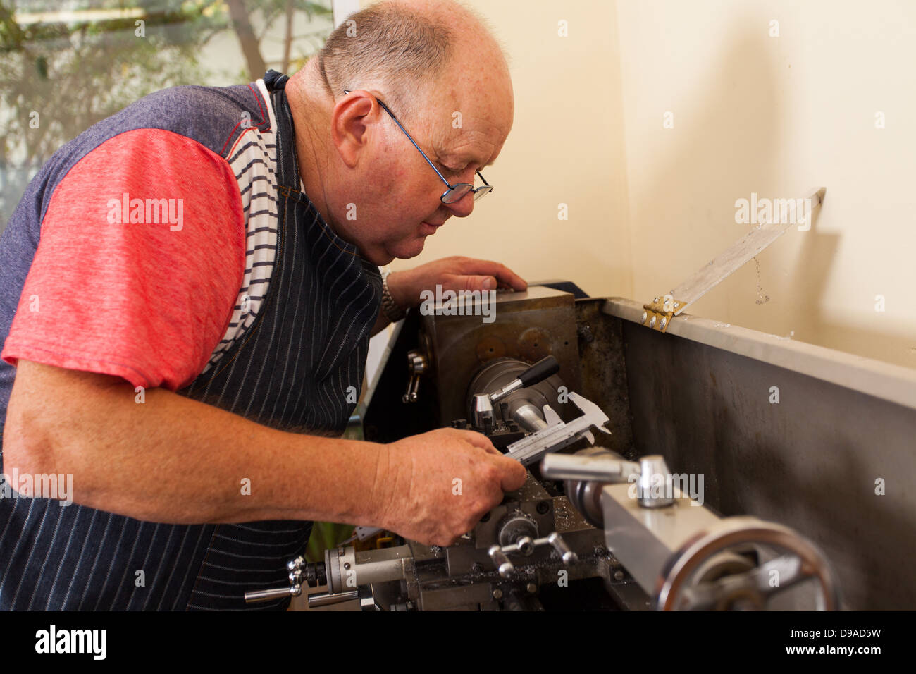 senior man operating lathe machine in workshop Stock Photo - Alamy