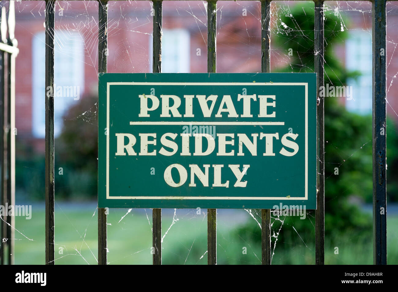 Green private residents only sign on a wrought iron gate surrounded ...