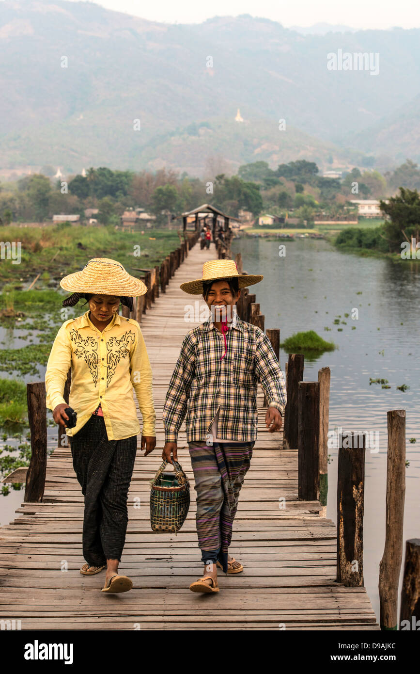 Burmese girls crossing a bridge on their way back to the village Inle ...