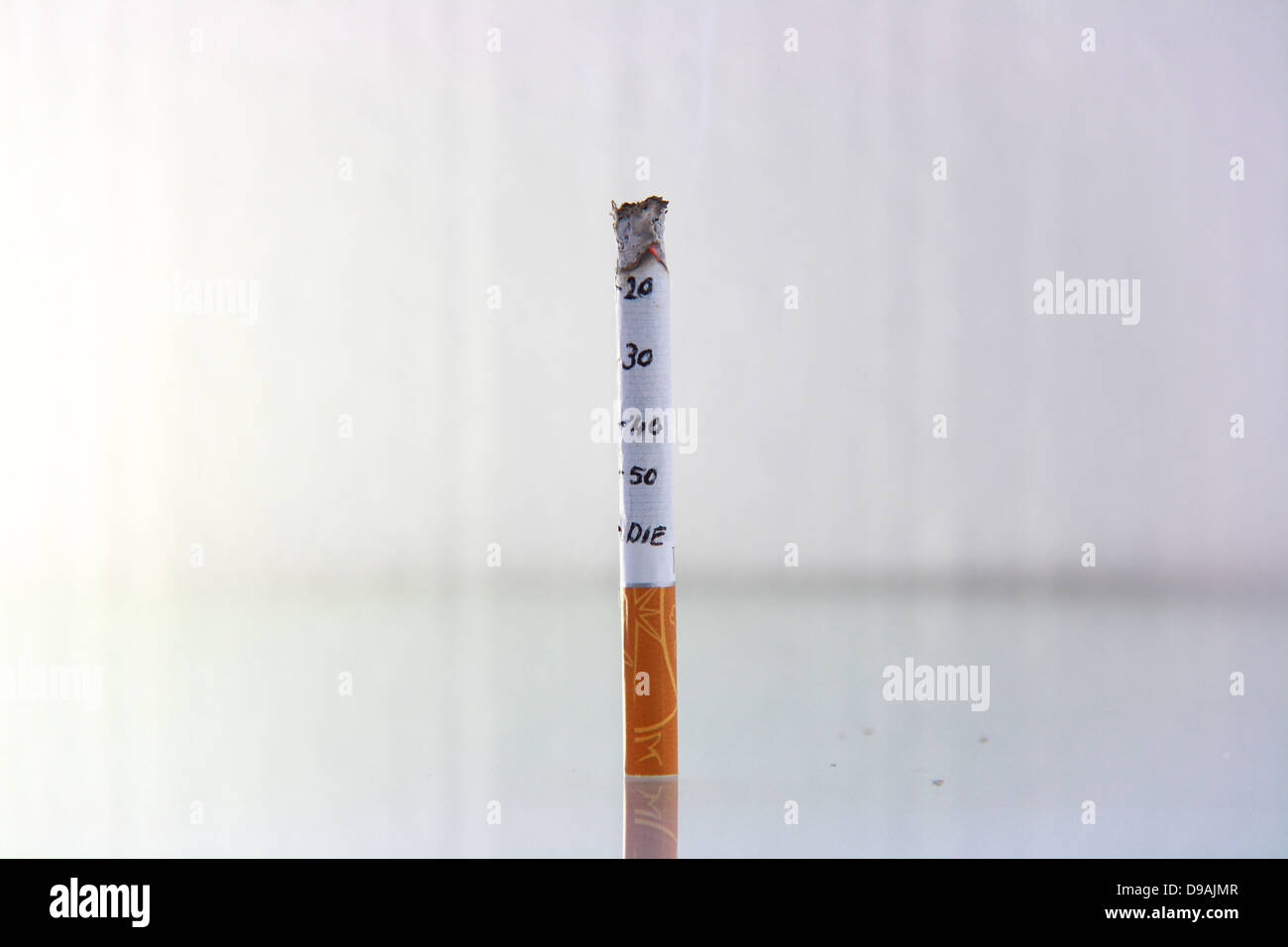 cigarette burning in front of white background Stock Photo - Alamy