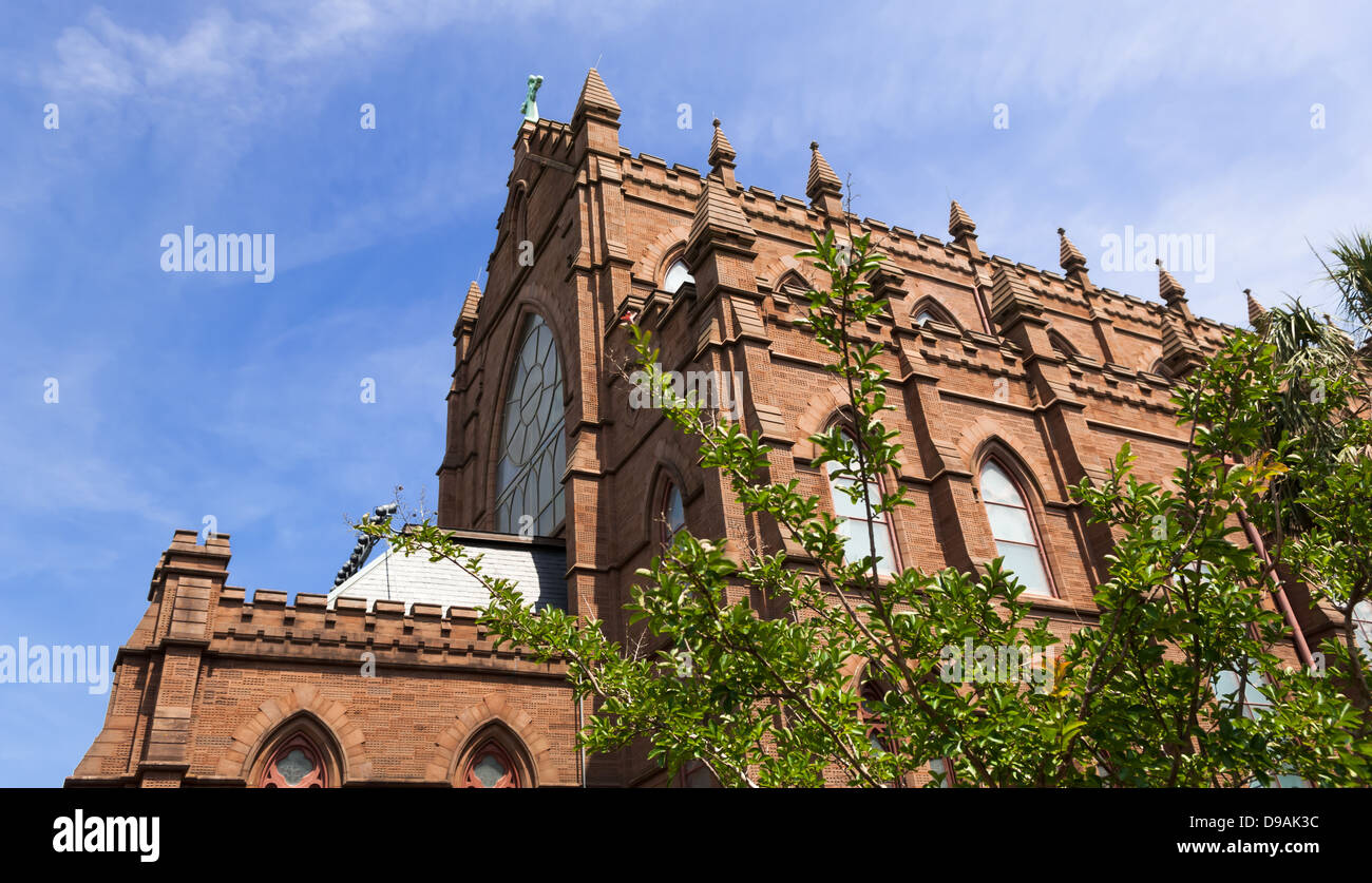 Red brick church highlighted by sunlight and blue skies in charleston ...
