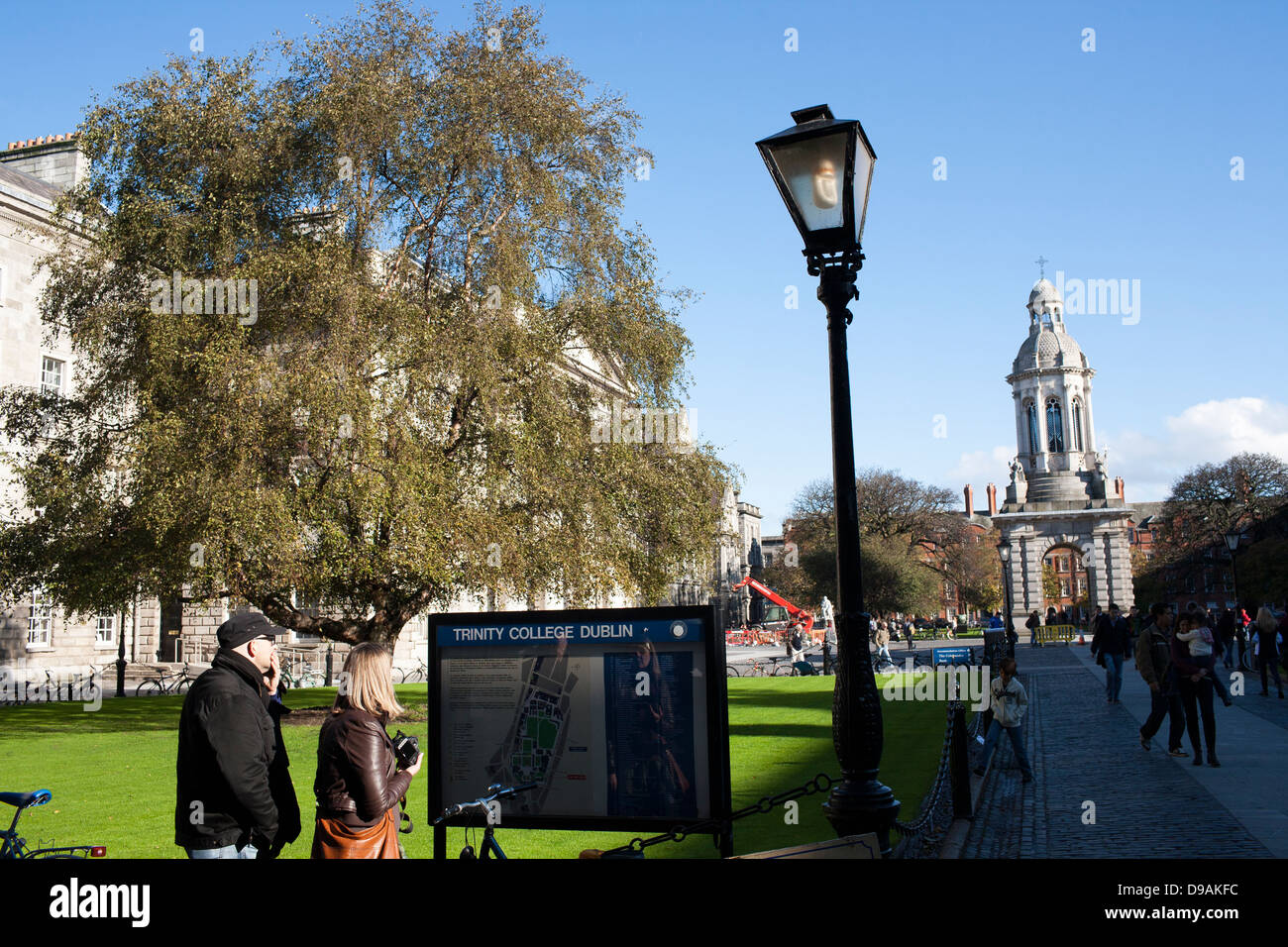 Tourists consult a map of the grounds inside of Trinity College Dublin ...