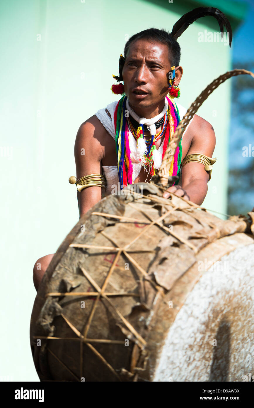 Naga tribal man in traditional outfit playing drum, Hornbill Festival ...