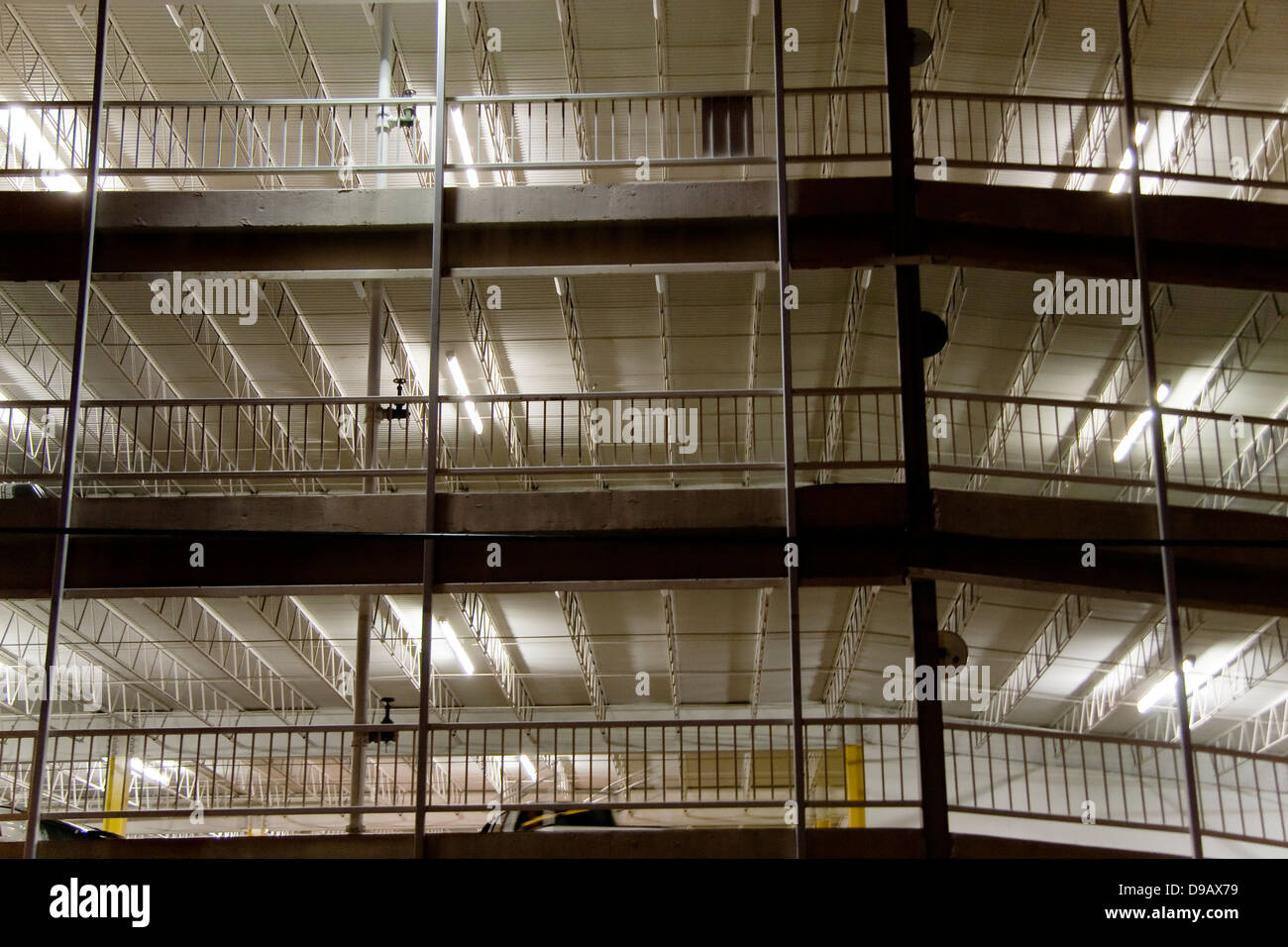 Repeating pattern of metal ceilings on multi level parking lot at night ...