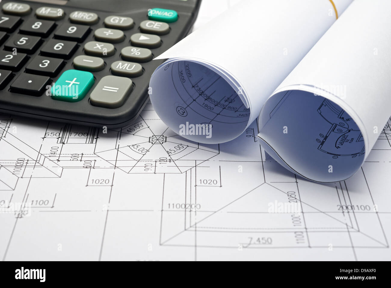 Architectural plan rolled up and calculator Stock Photo - Alamy