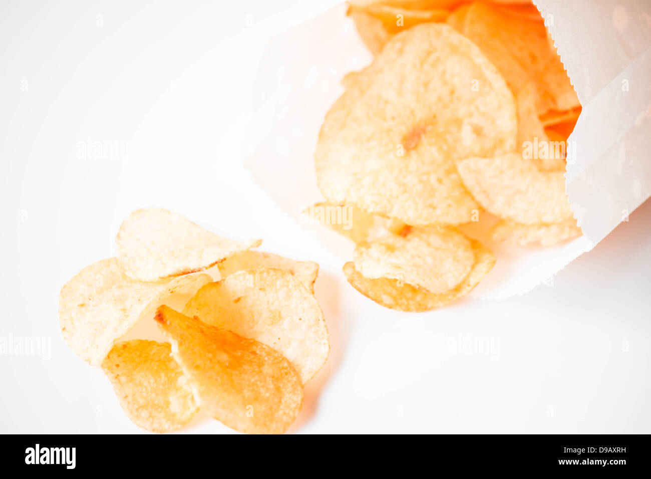 Potato chips snack falling out of the bag Stock Photo - Alamy