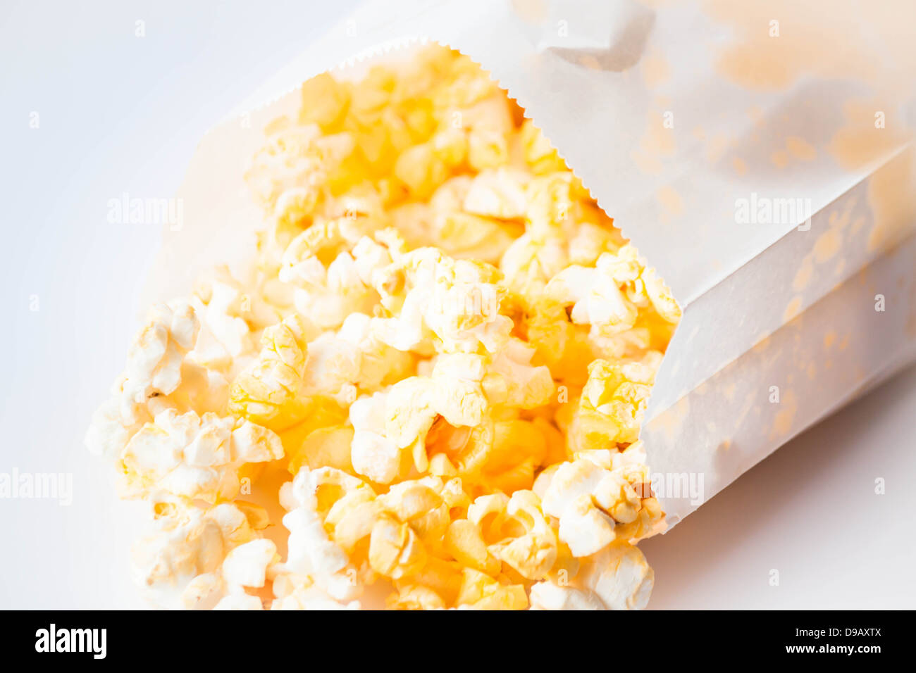 Close up butter popcorn falling out of paper bag Stock Photo - Alamy