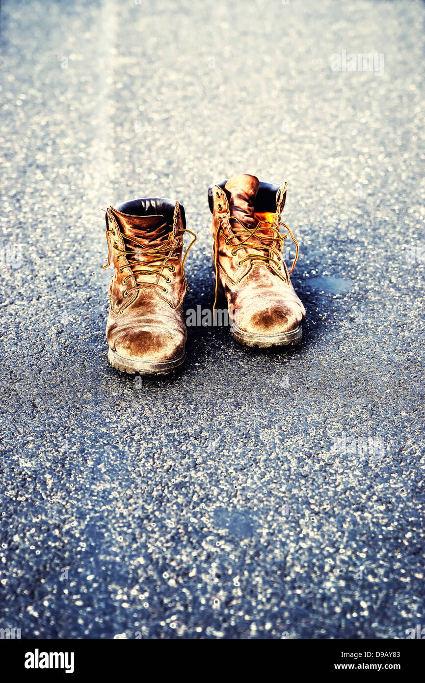Pair of old shoes on road Stock Photo - Alamy