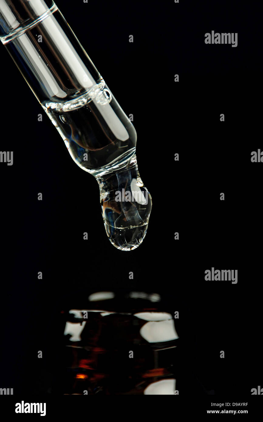 Pipette with liquid on black background Stock Photo - Alamy