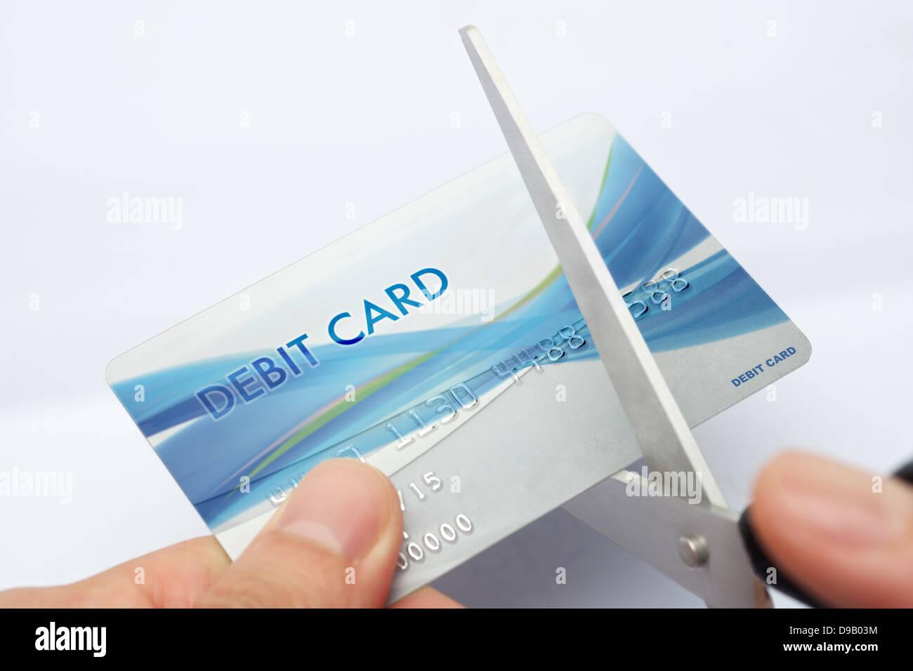 Debitit card being cut up with scissor, held by hand Stock Photo - Alamy