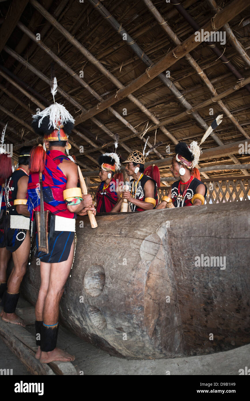 Naga tribal men in traditional outfit playing log drum, Hornbill ...