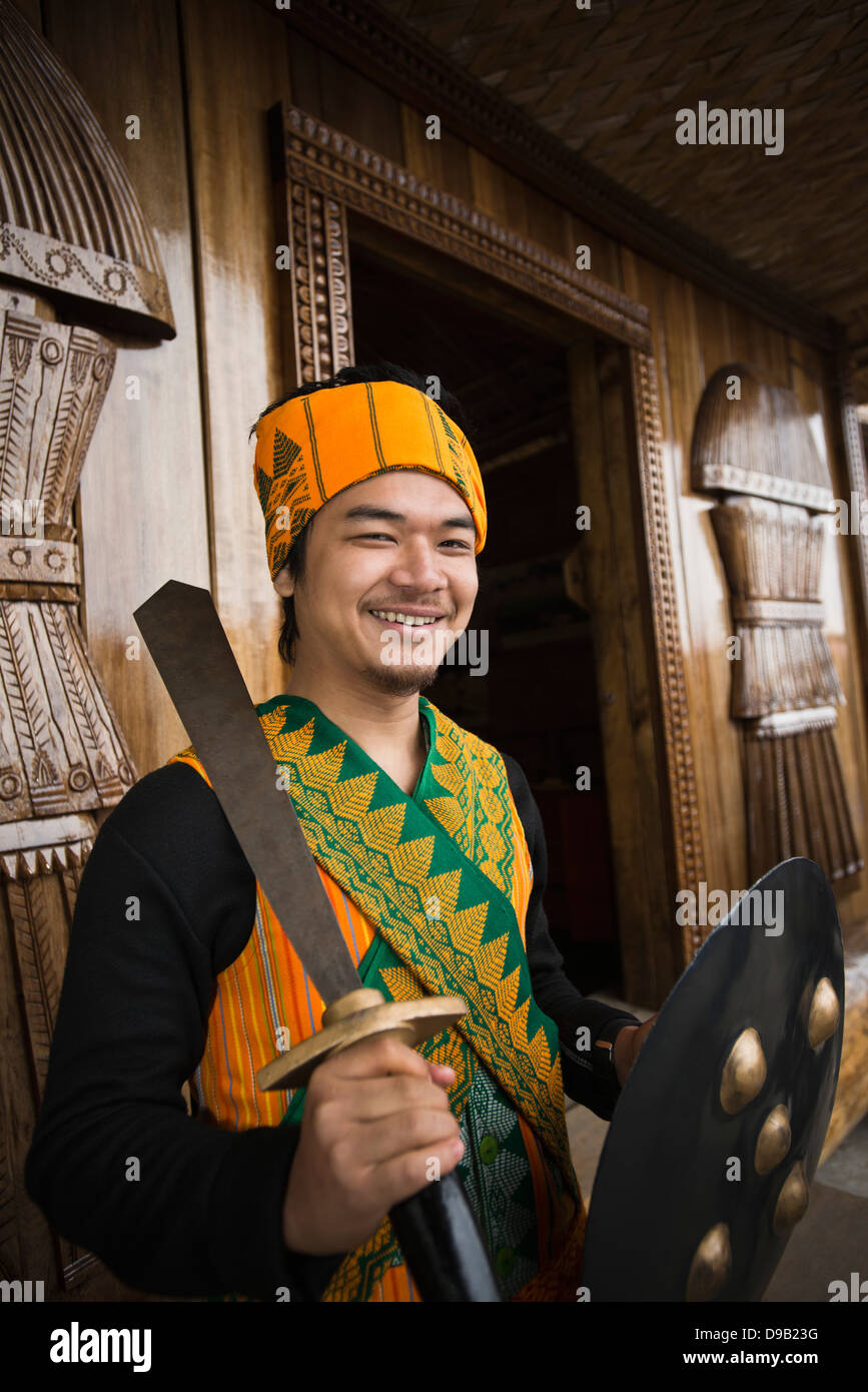Naga tribal man standing with sword and shield, Hornbill Festival ...