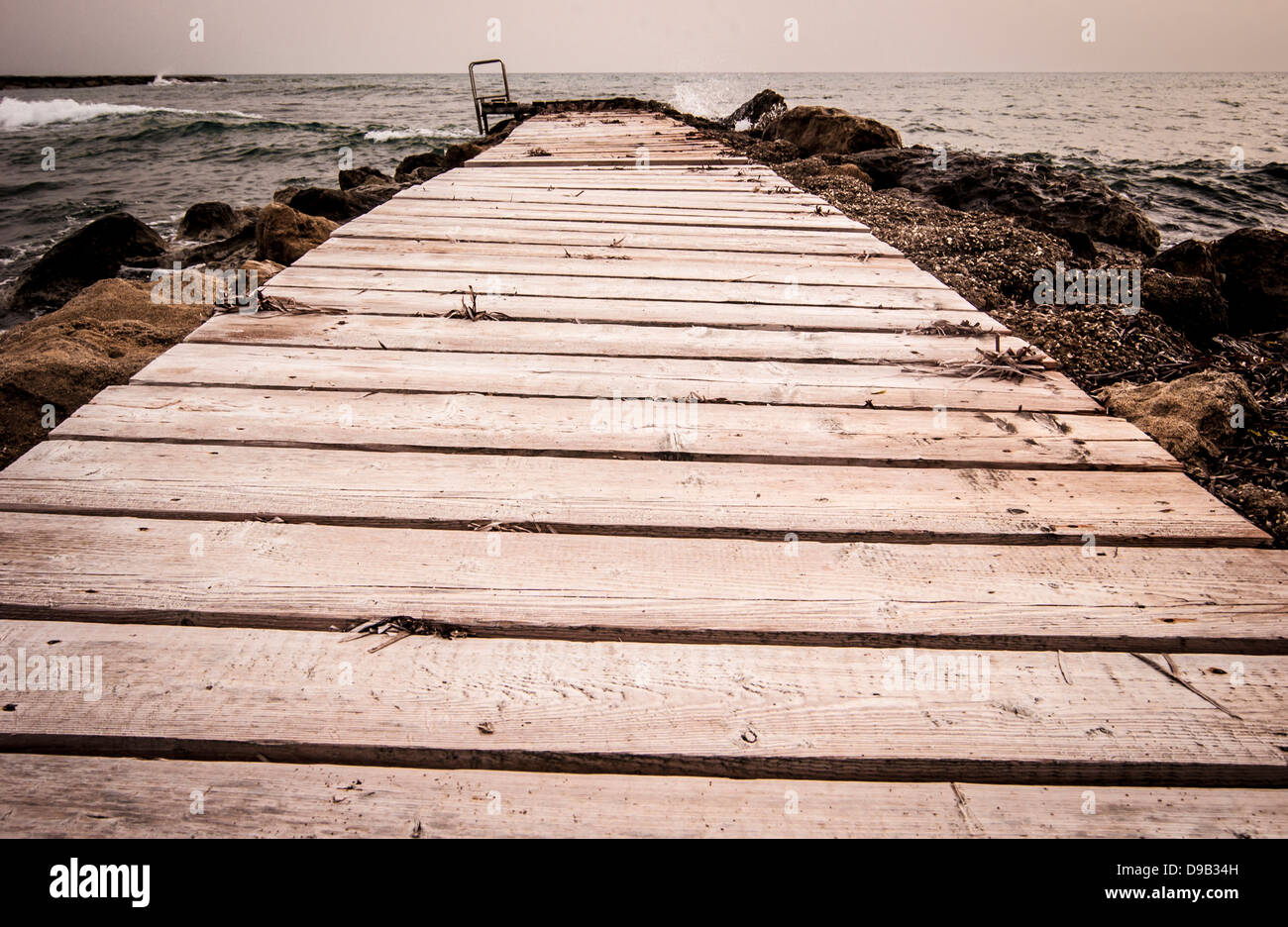 Wooden jetty with metal steps leading into sea Stock Photo - Alamy