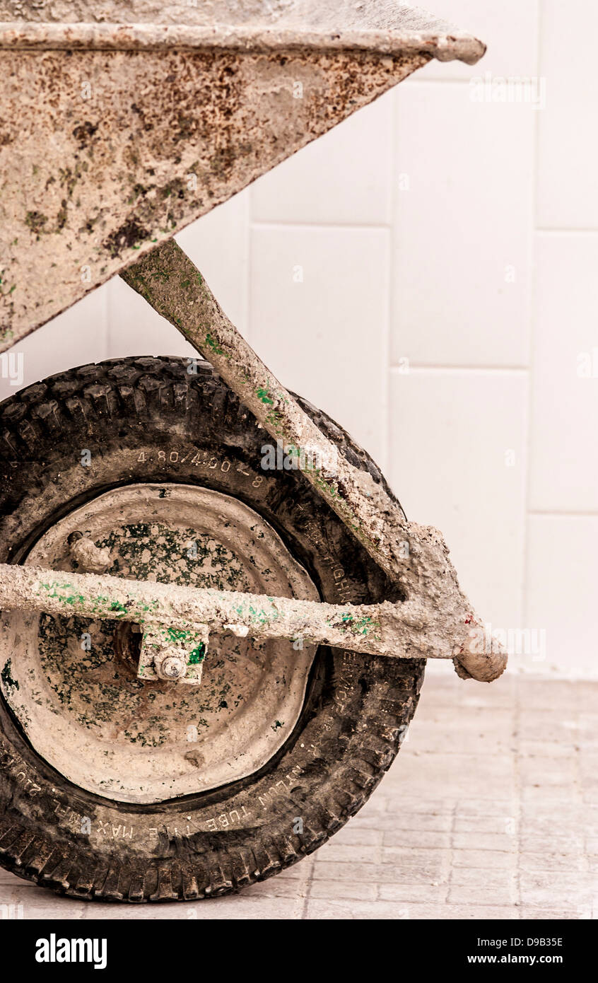 Closeup of the front wheel of cement covered construction wheelbarrow ...