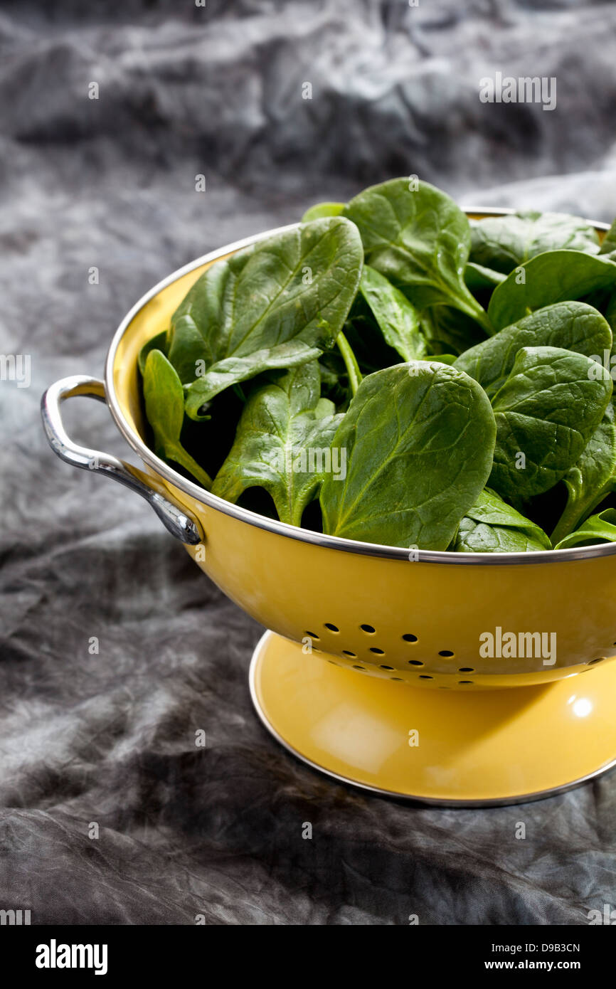 Spinach leafs in yellow colander, close up Stock Photo - Alamy