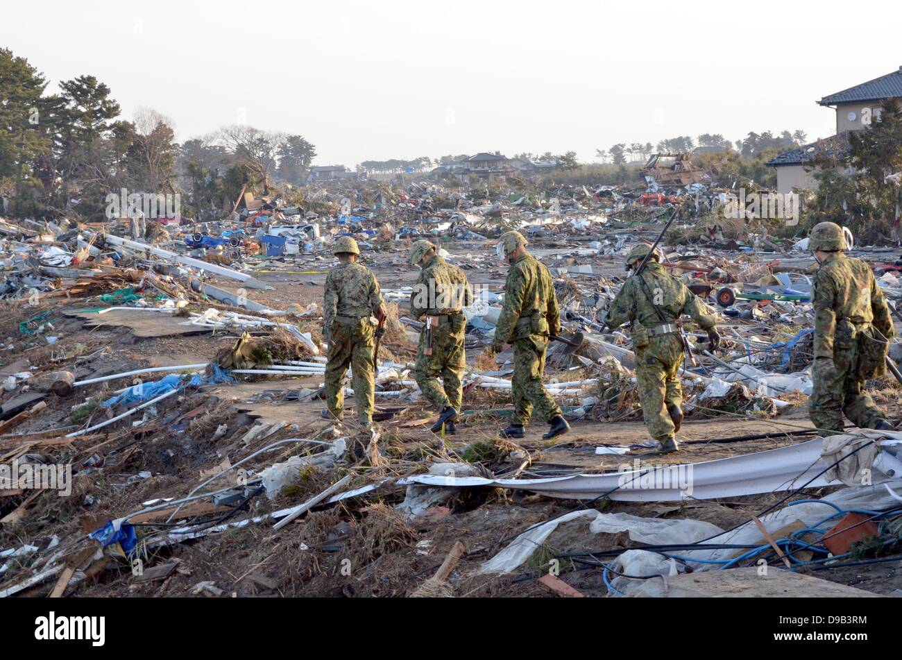 A Japan Ground Self-Defense Force trooper shifts through the debris as ...