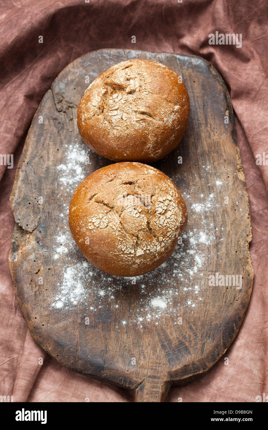 Rye roll on chopping board, close up Stock Photo - Alamy