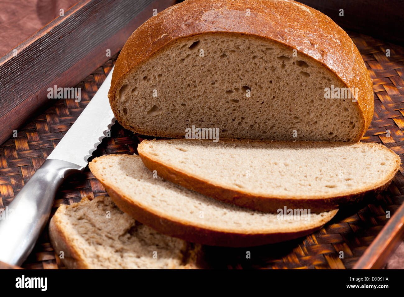 Rustic rye mix bread with knife in tray, close up Stock Photo - Alamy
