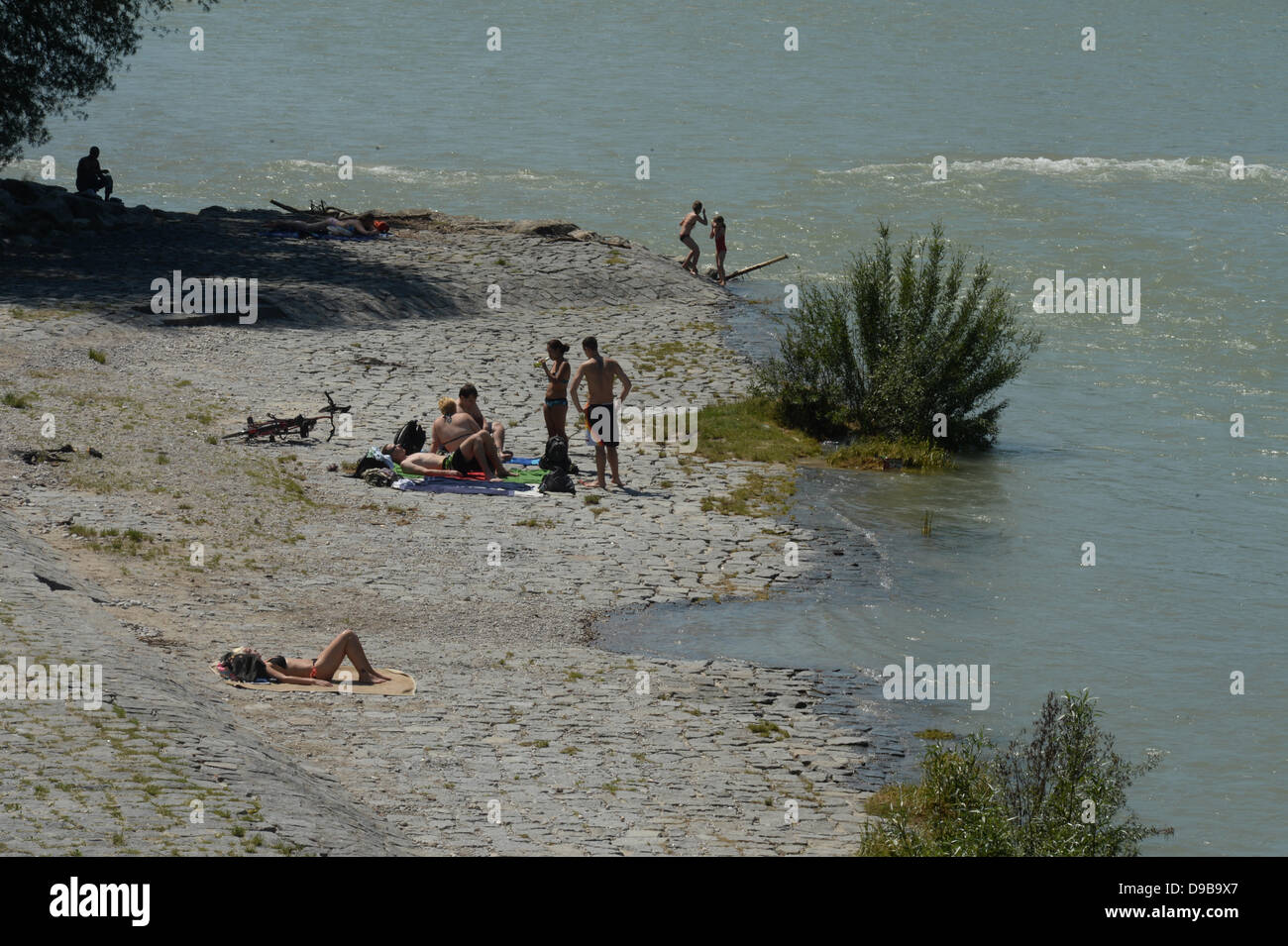 People bathe in the sun near a bridge of the zoo Tierpark Hellabrunn at ...