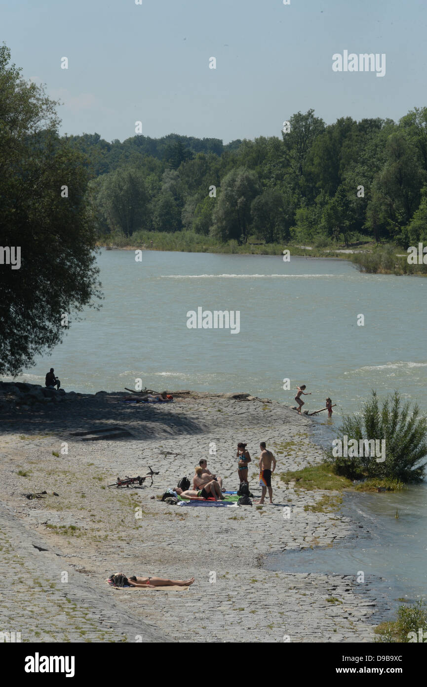 People bathe in the sun near a bridge of the zoo Tierpark Hellabrunn at ...